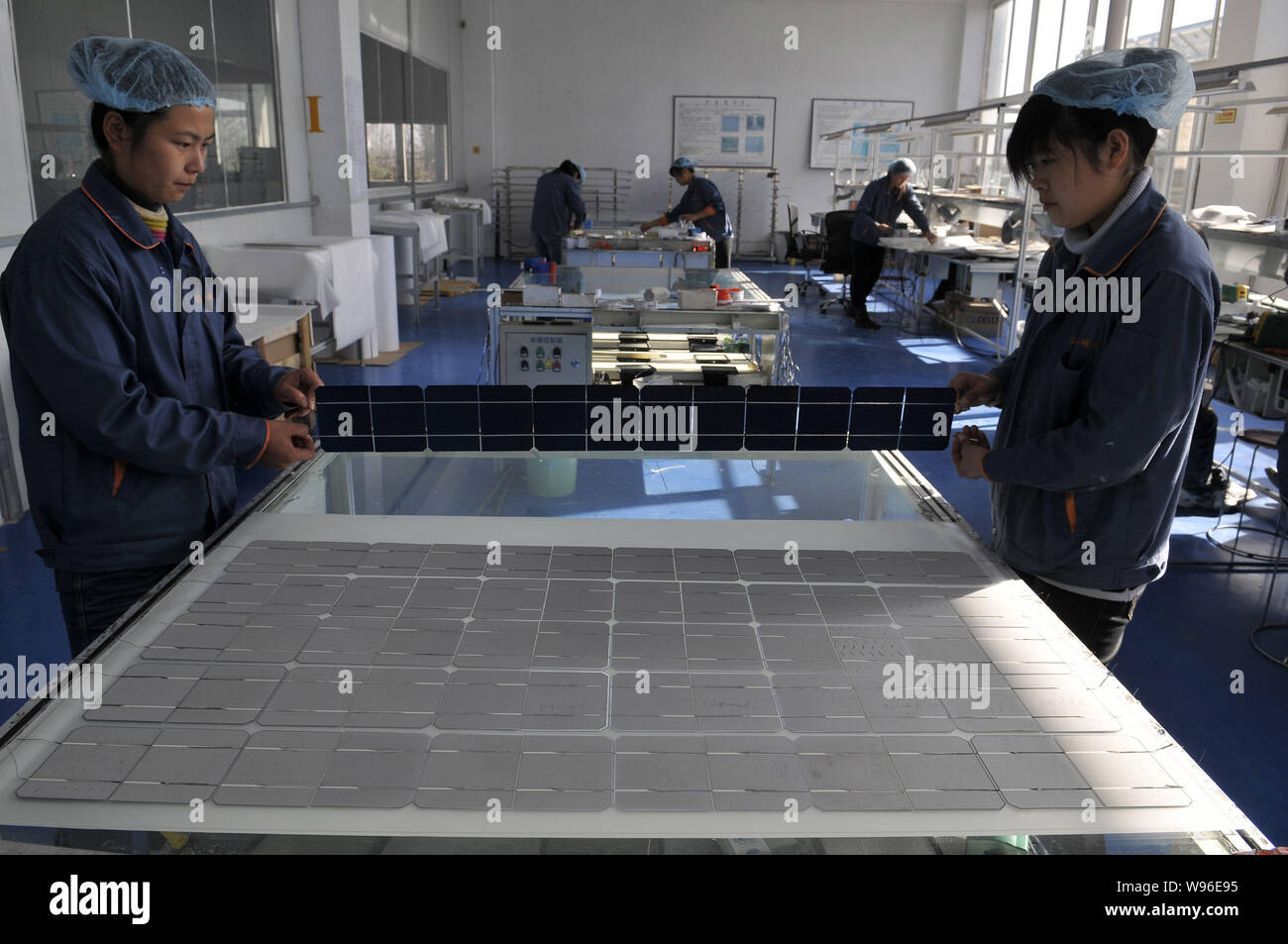 --File--Workers assemble solar panels at a factory in Rizhao, east ...