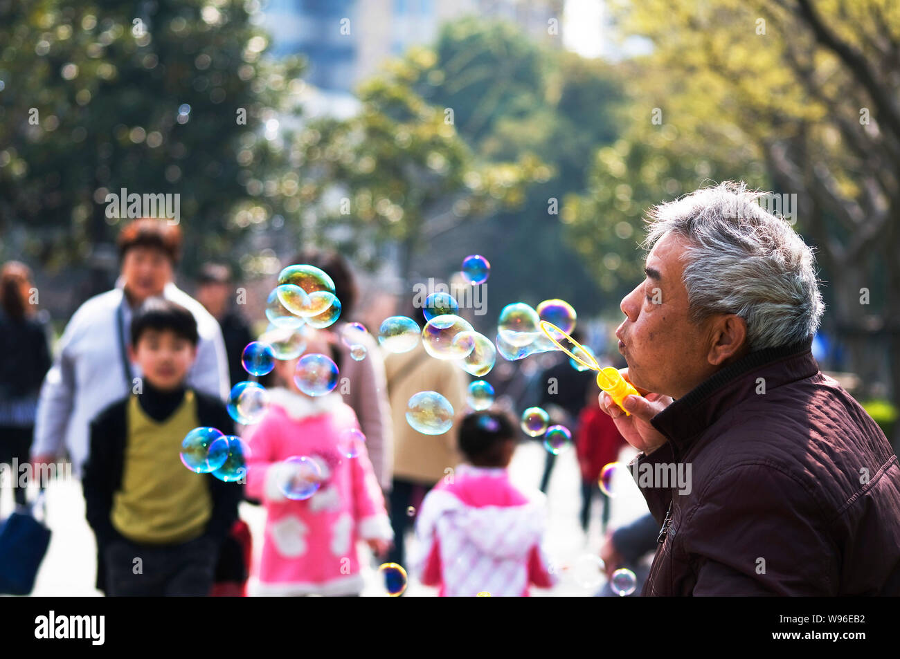 An old man blows bubbles along on Peoples Square in Shanghai, China, 7 ...