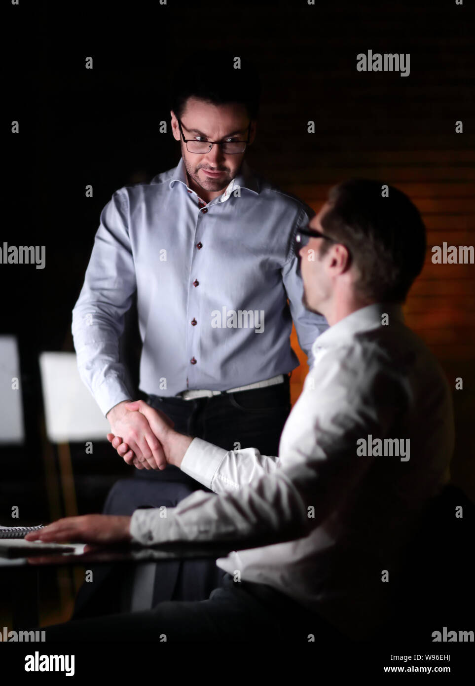 employees shaking hands near the desktop Stock Photo - Alamy