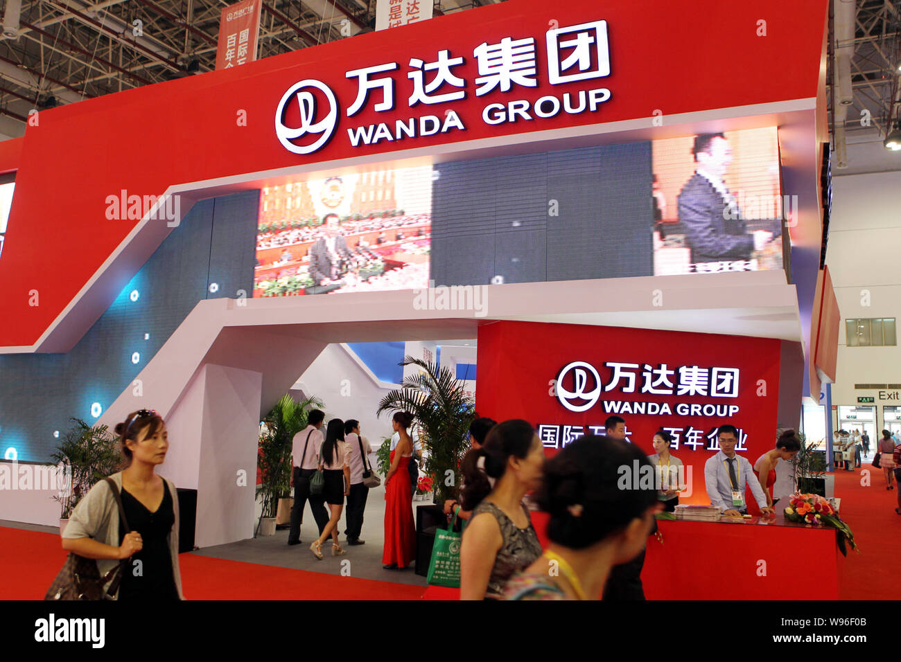 --FILE--Visitors walk past the stand of Wanda Group during a real ...