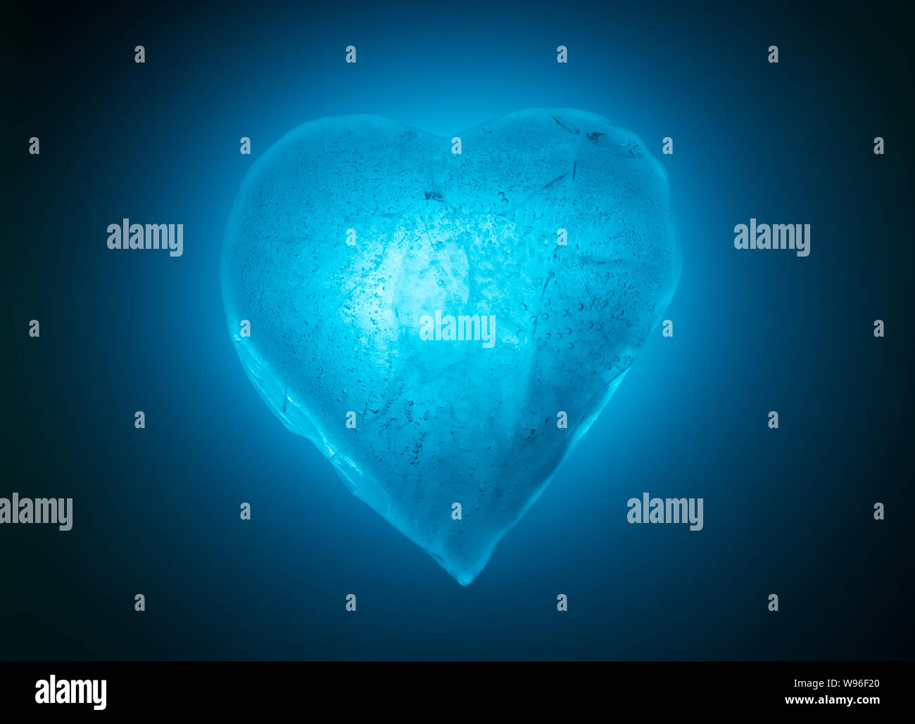 Ice frozen heart symbol of blue color close-up glowing in blue cold ...
