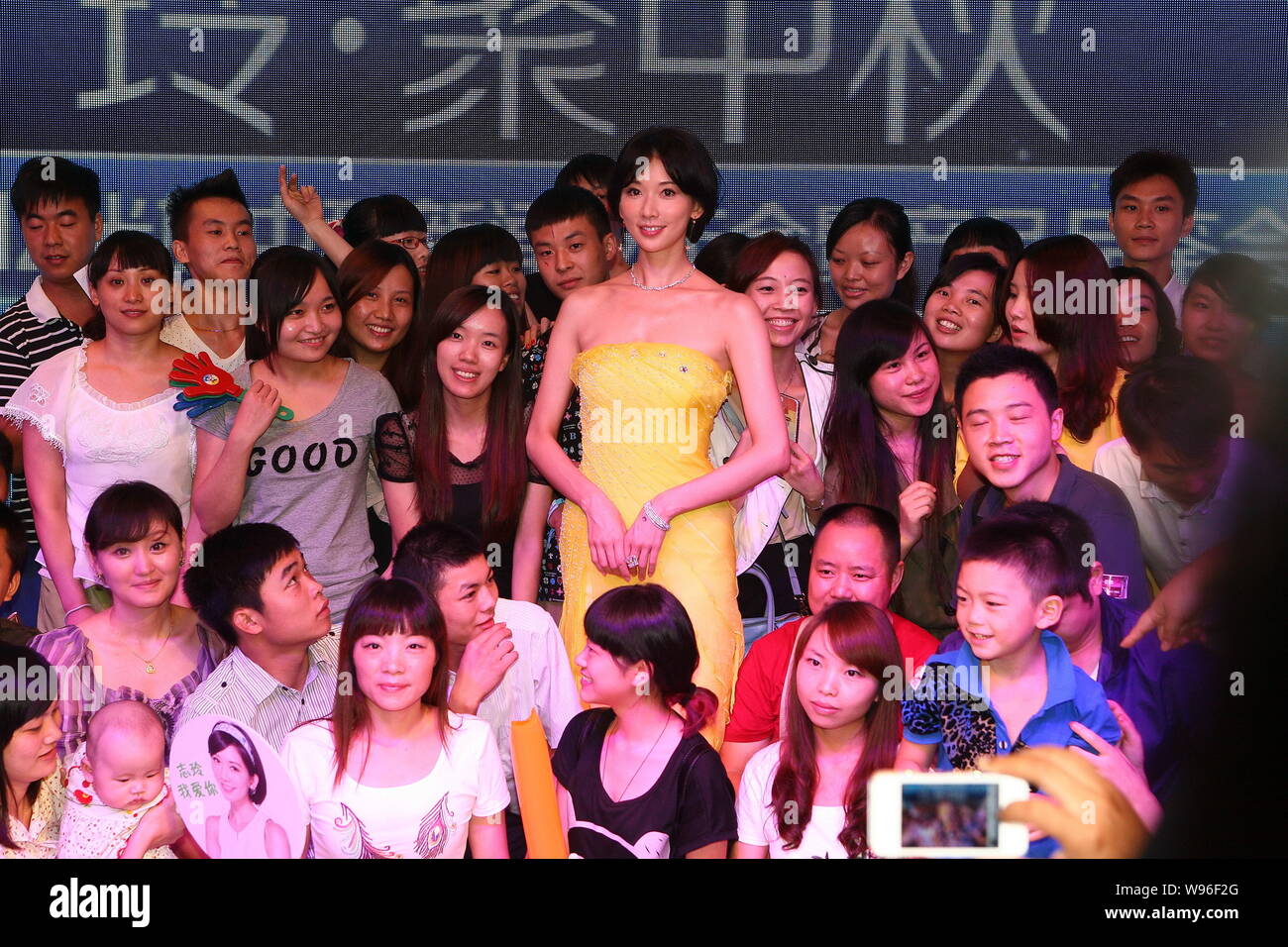 Taiwanese model and actress Lin Chi-ling (yellow) poses with fans ...