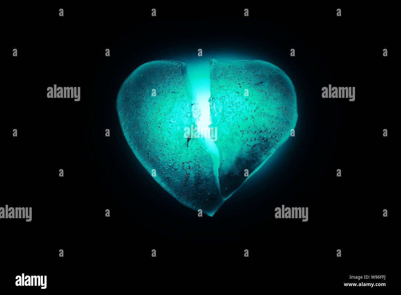 Ice frozen broken in half heart symbol of blue color close-up glowing ...