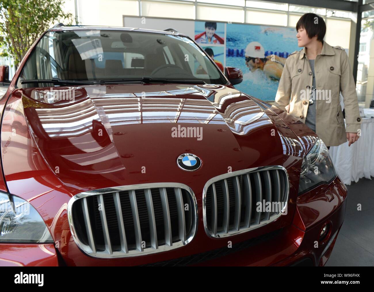 Chinese Olympic swimming champion Ye Shiwen looks at her BMW X5 during ...
