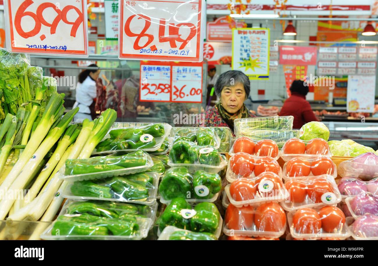 A Chinese shopper buys vegetables at a supermarket in Hangzhou city ...