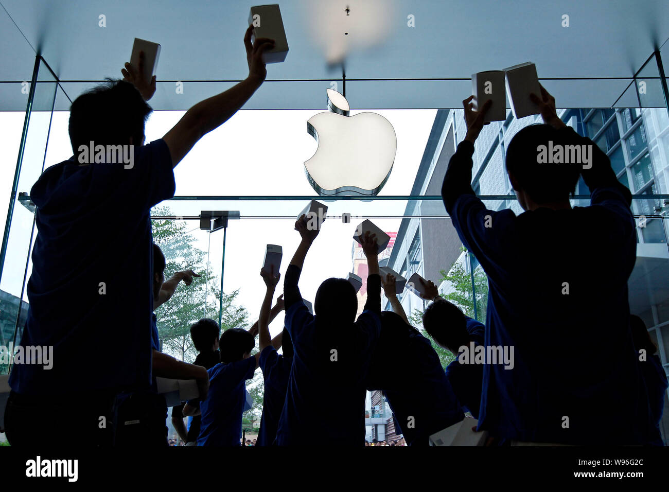 Staff members hold up souvenirs to be distributed to customers and ...