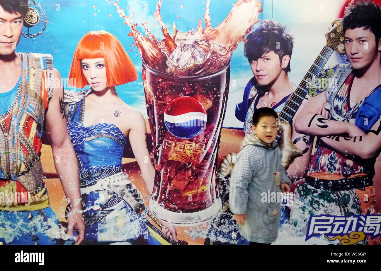 --FILE--A kid walks past an advertisement for Pepsi cola of PepsiCo in ...