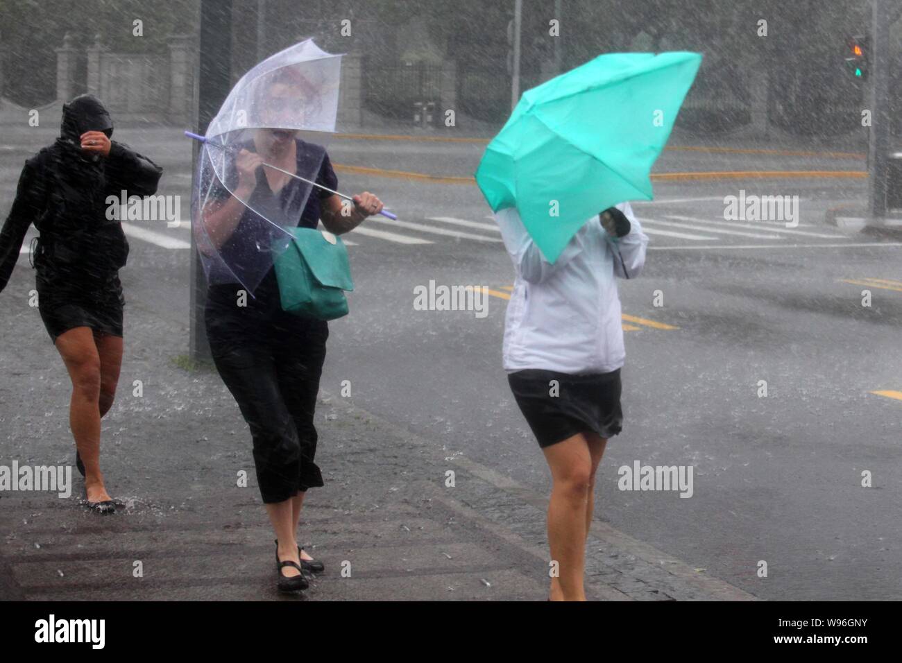 Pedestrians brave strong wind and heavy rain caused by Typhoon Haikui ...