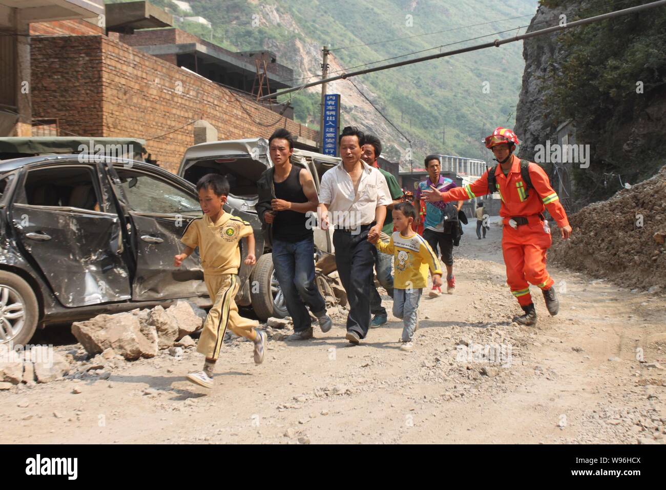 A Chinese rescuer evacuates local villagers in the aftermath of the 5.6 ...