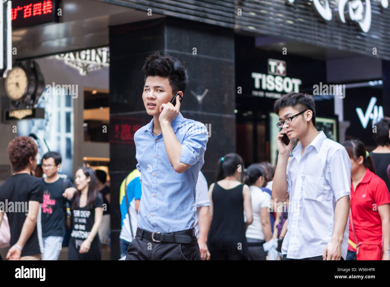 Chinese mobile phone users are pictured on the street in Guangzhou city ...