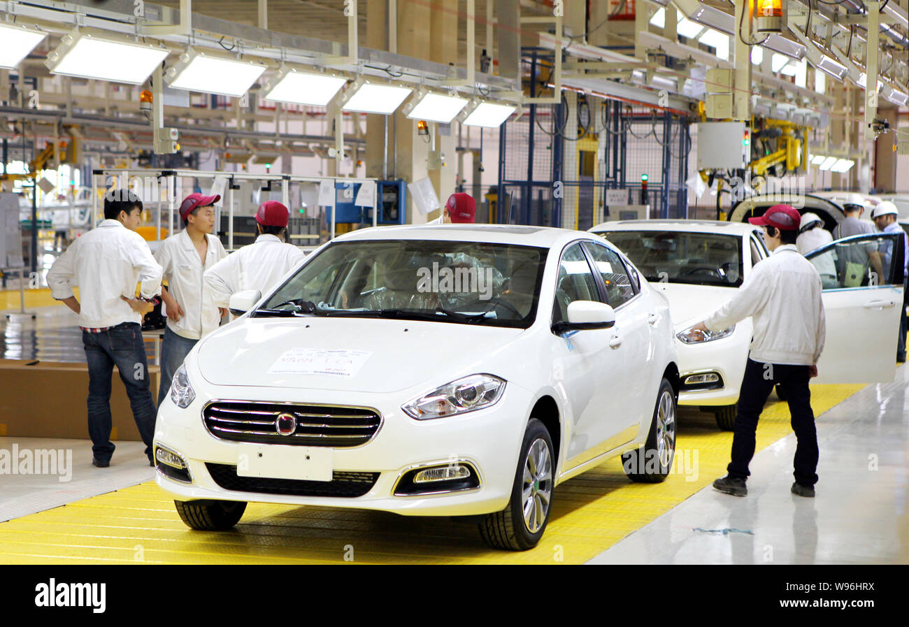 Chinese workers check Fiat Viaggio cars on the assembly line at the GAC ...