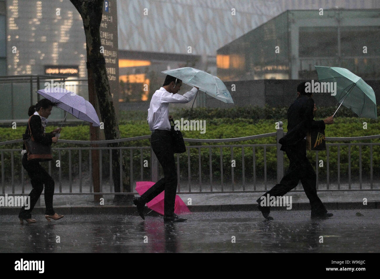 Pedestrians brave strong wind and heavy rain caused by Typhoon Haikui ...