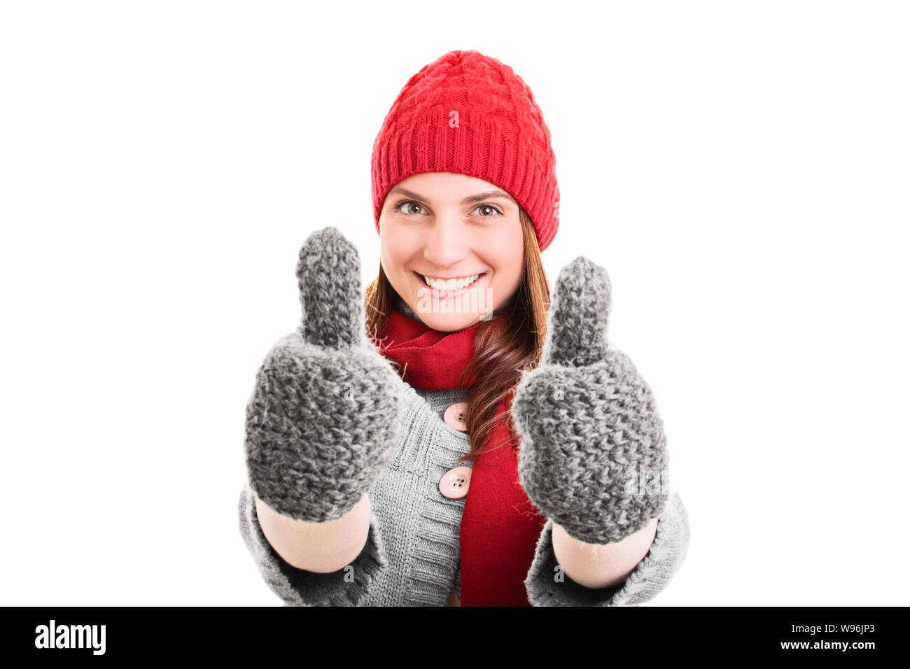 A portrait of a beautiful smiling young girl in winter clothes giving a ...