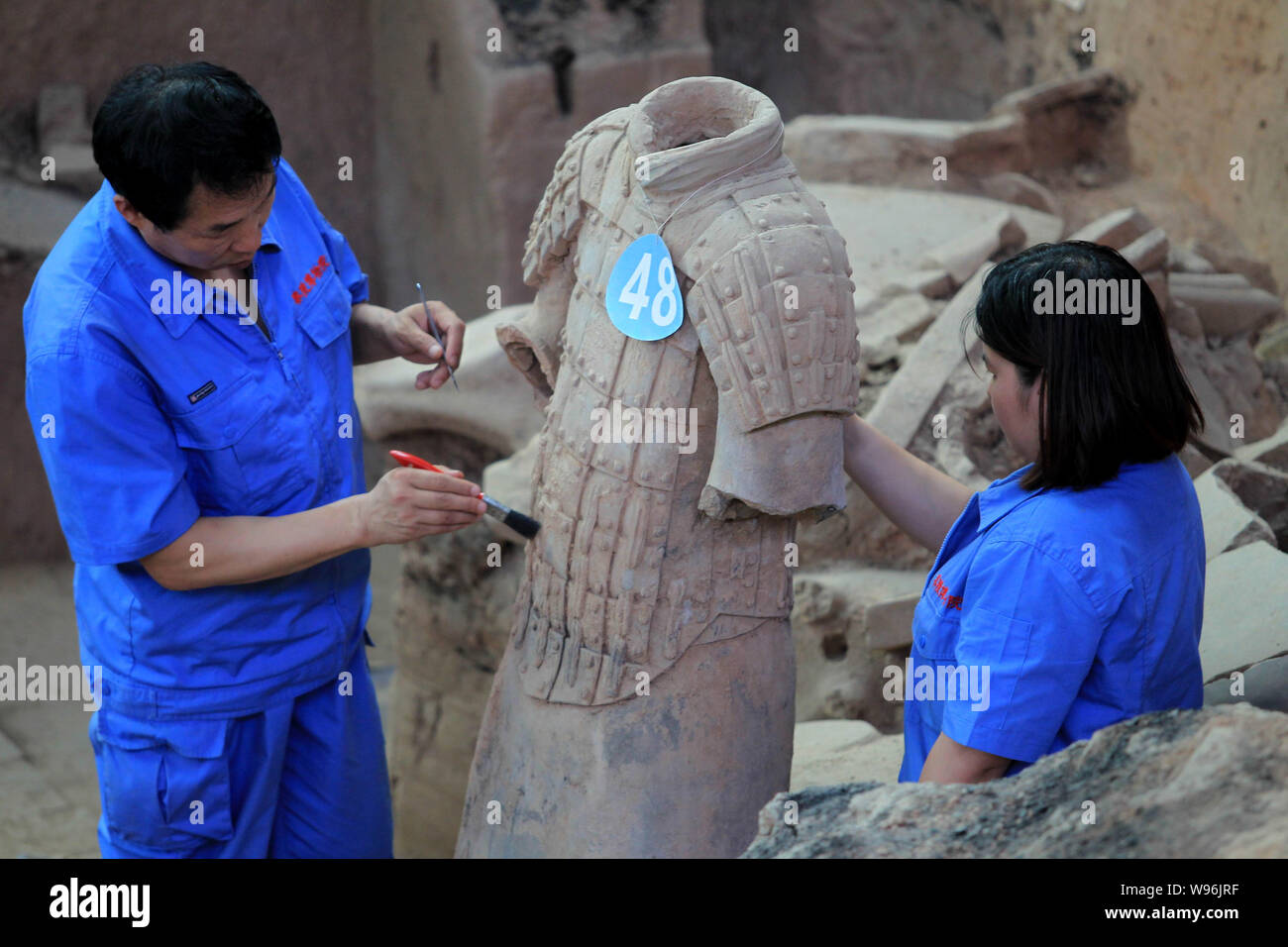 Chinese archaeologists work on a terracotta warrior in the No.1 Pit at the Museum of the Terra ...