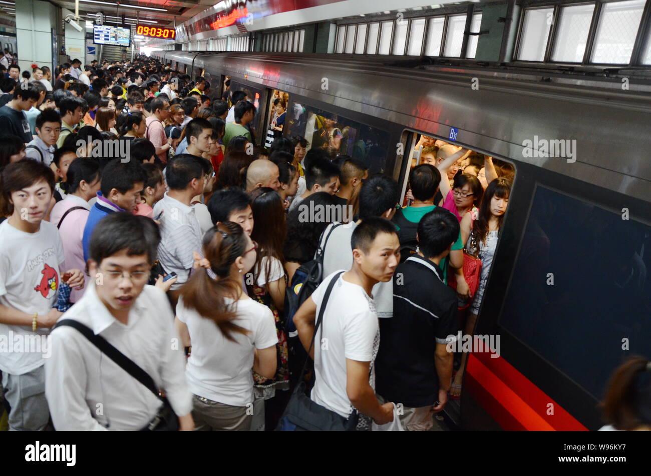 --FILE--A crowd of passengers queue up in front of an overcrowded Metro ...