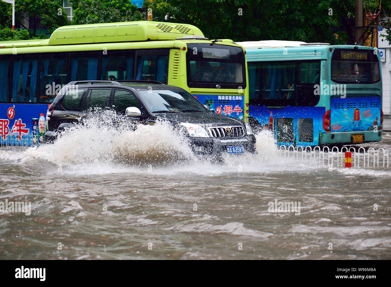 Vehicles travel on a flooded road in heavy rain caused by Typhoon ...