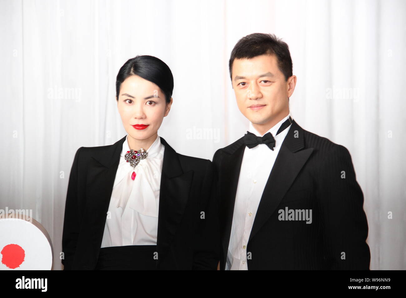 Hong Kong singer Faye Wong and her husband, Chinese actor Li Yapeng pose during a charity event ...