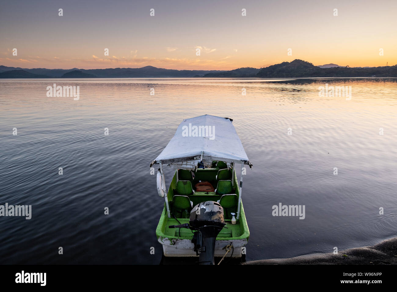 A tour boat along the shore of Lake Catemaco at sunset in Catemaco ...