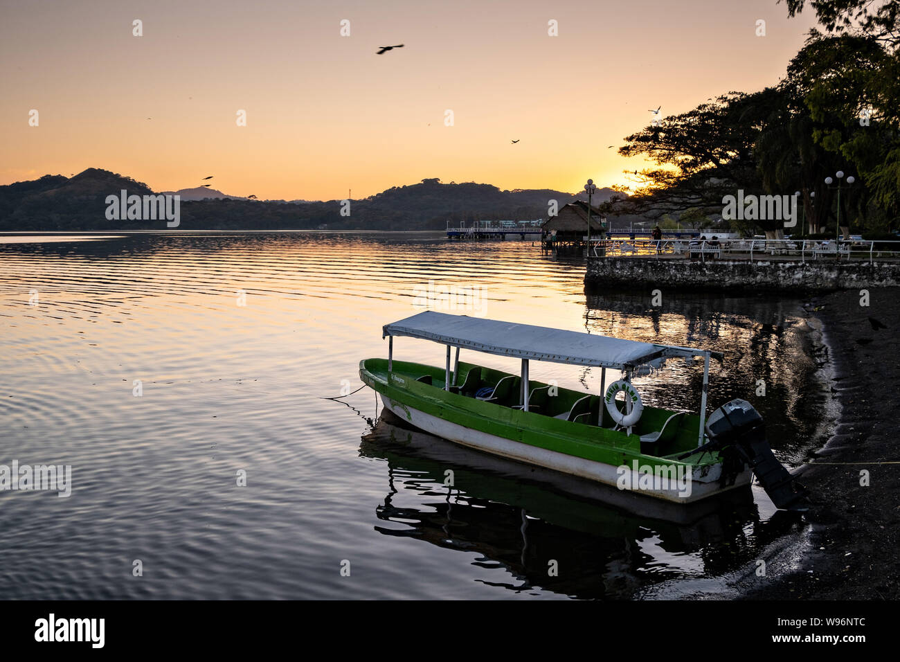 A tour boat along the shore of Lake Catemaco at sunset in Catemaco ...