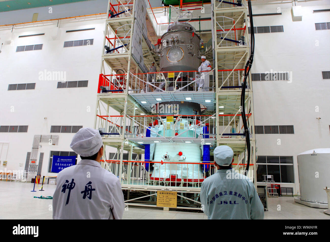 Chinese aerospace engineers connect the orbital module, top, with the ...