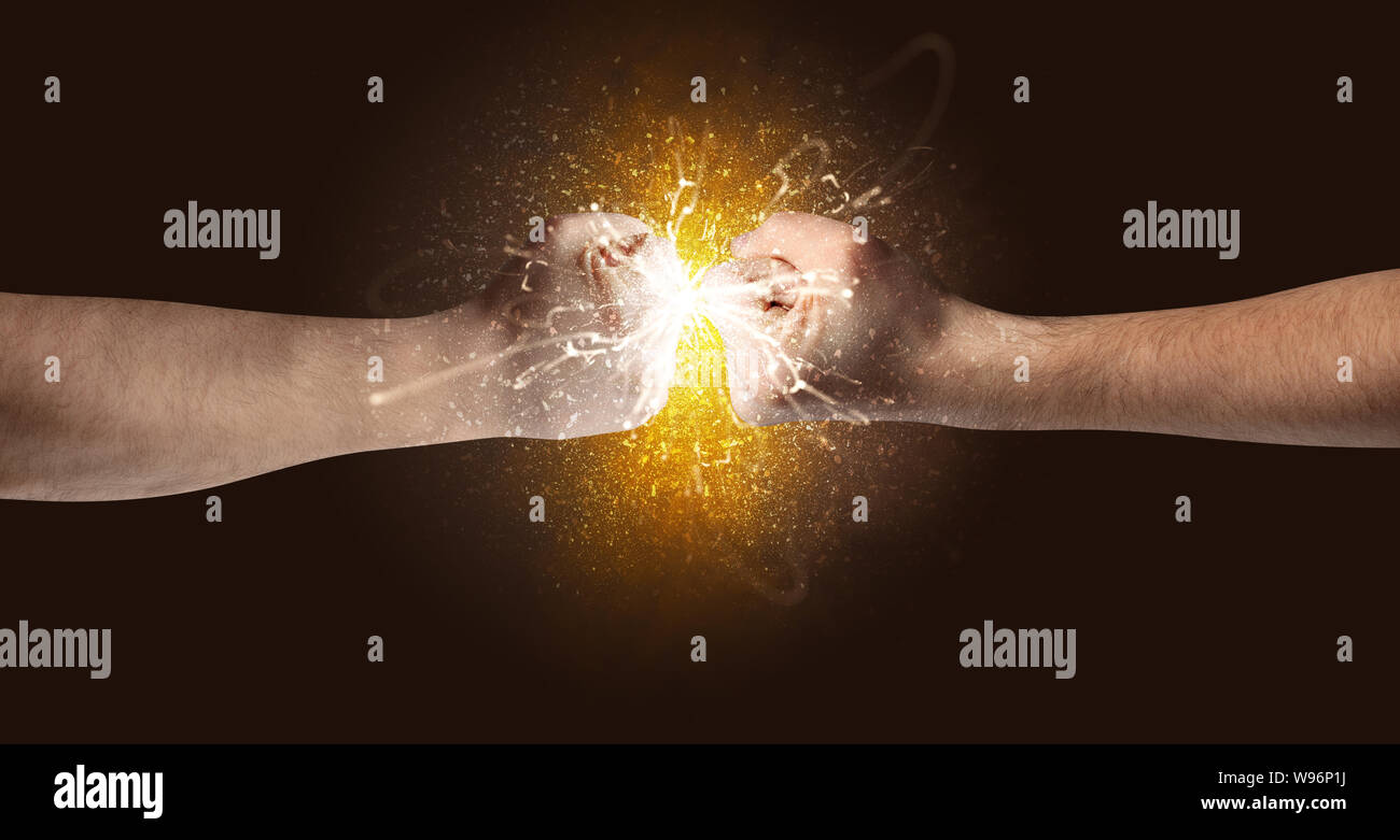 Two hands fighting with orange dust, spark, glow and smoke concept ...