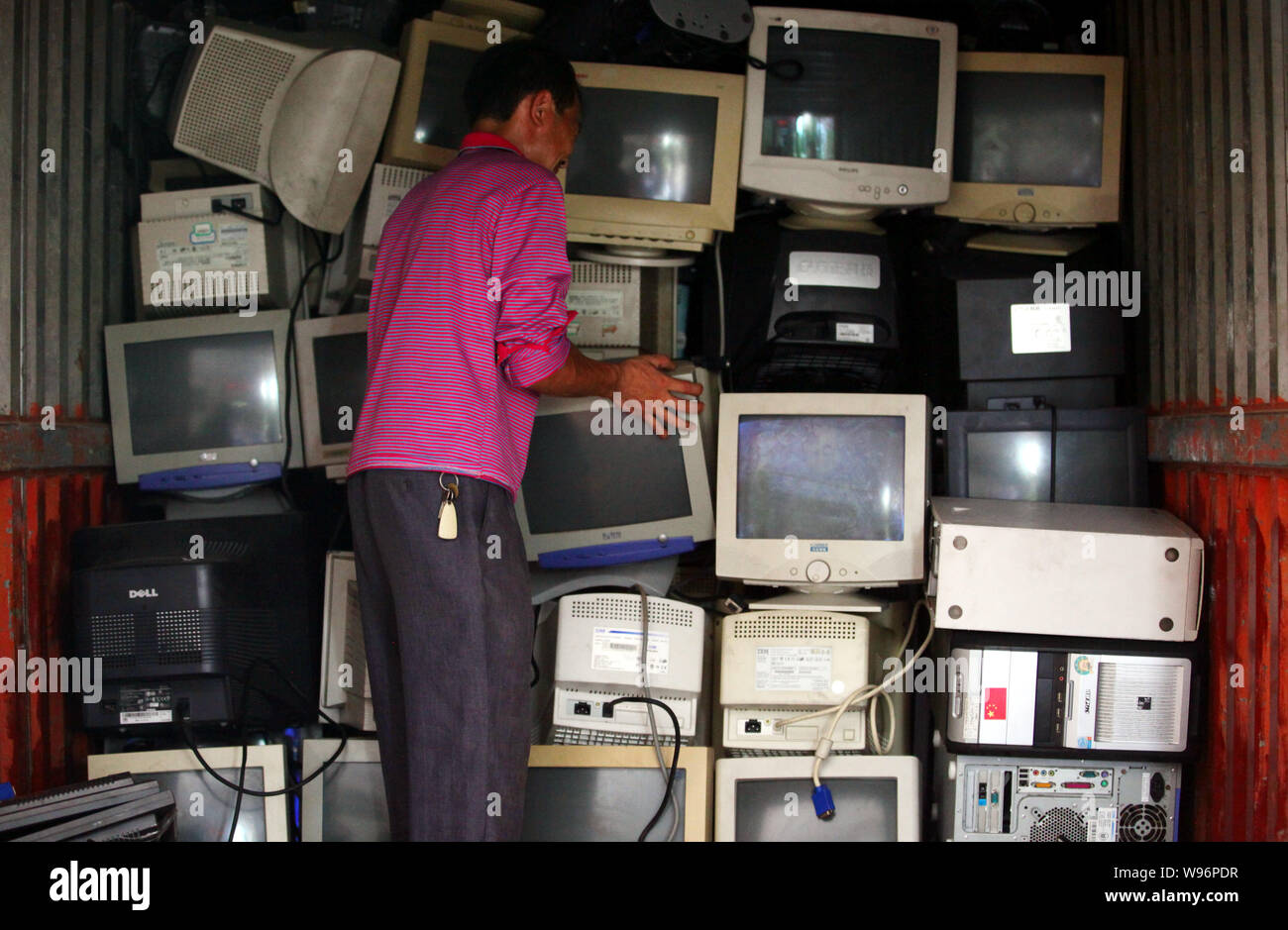 A Chinese worker loads a van with waste computers in Haikou city, south ...