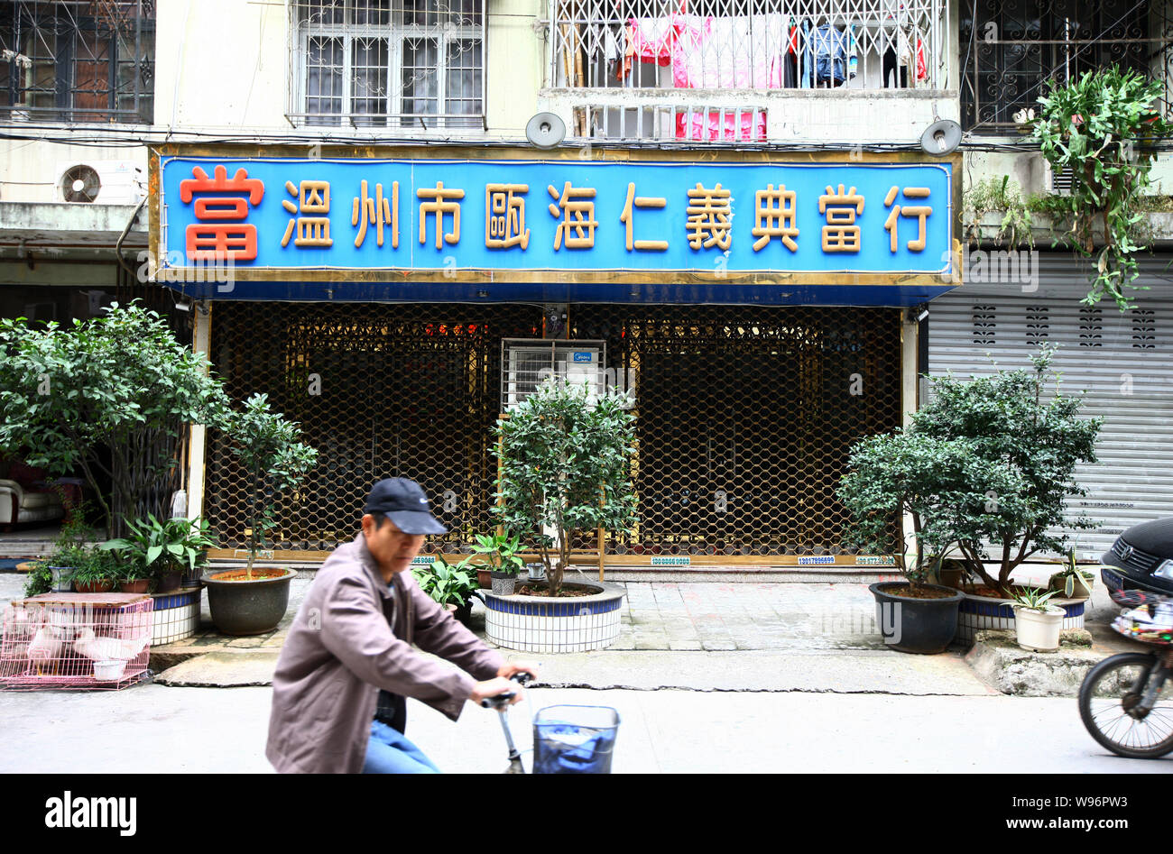 --File--A man rides past a pawn shop in Wenzhou, east Chinas Zhejiang ...