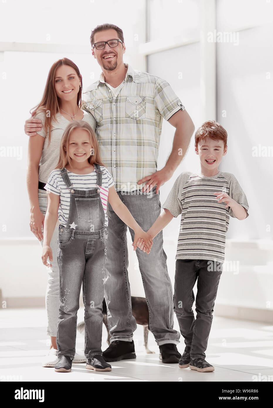 family with two children standing in a new house Stock Photo - Alamy