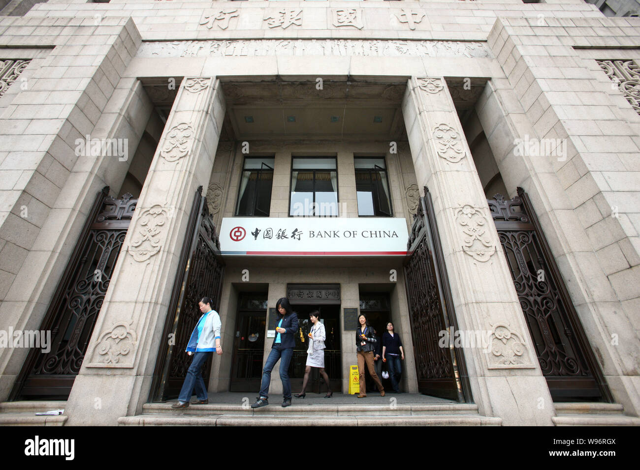 Chinese employees walk out from a branch of Bank of China (BOC) in ...