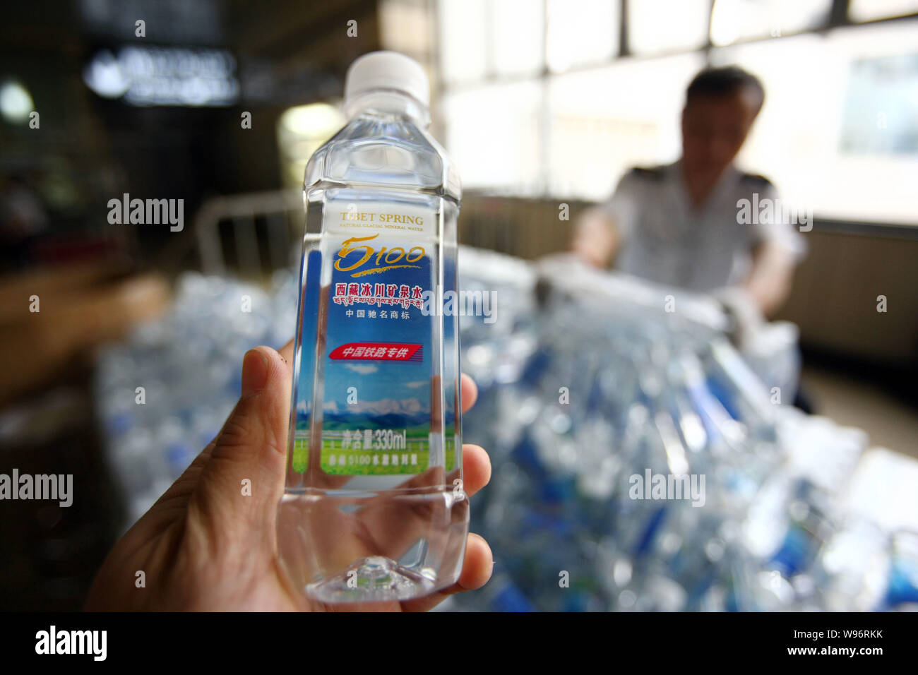 A Chinese passenger takes a bottle of Tibet 5100 mineral water at the ...