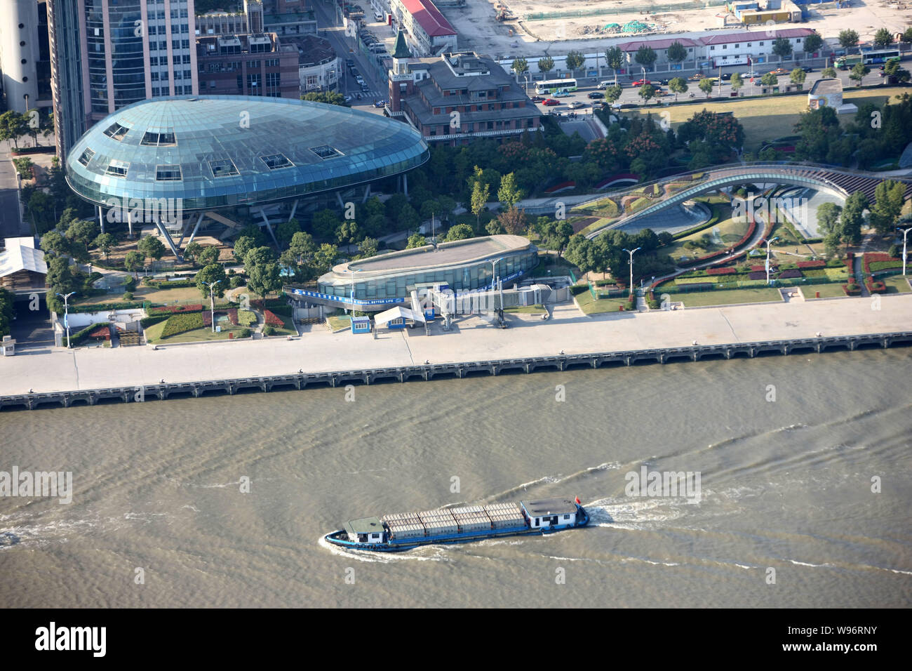 A cargo boat passes by the Shanghai Port International Cruise Terminal ...