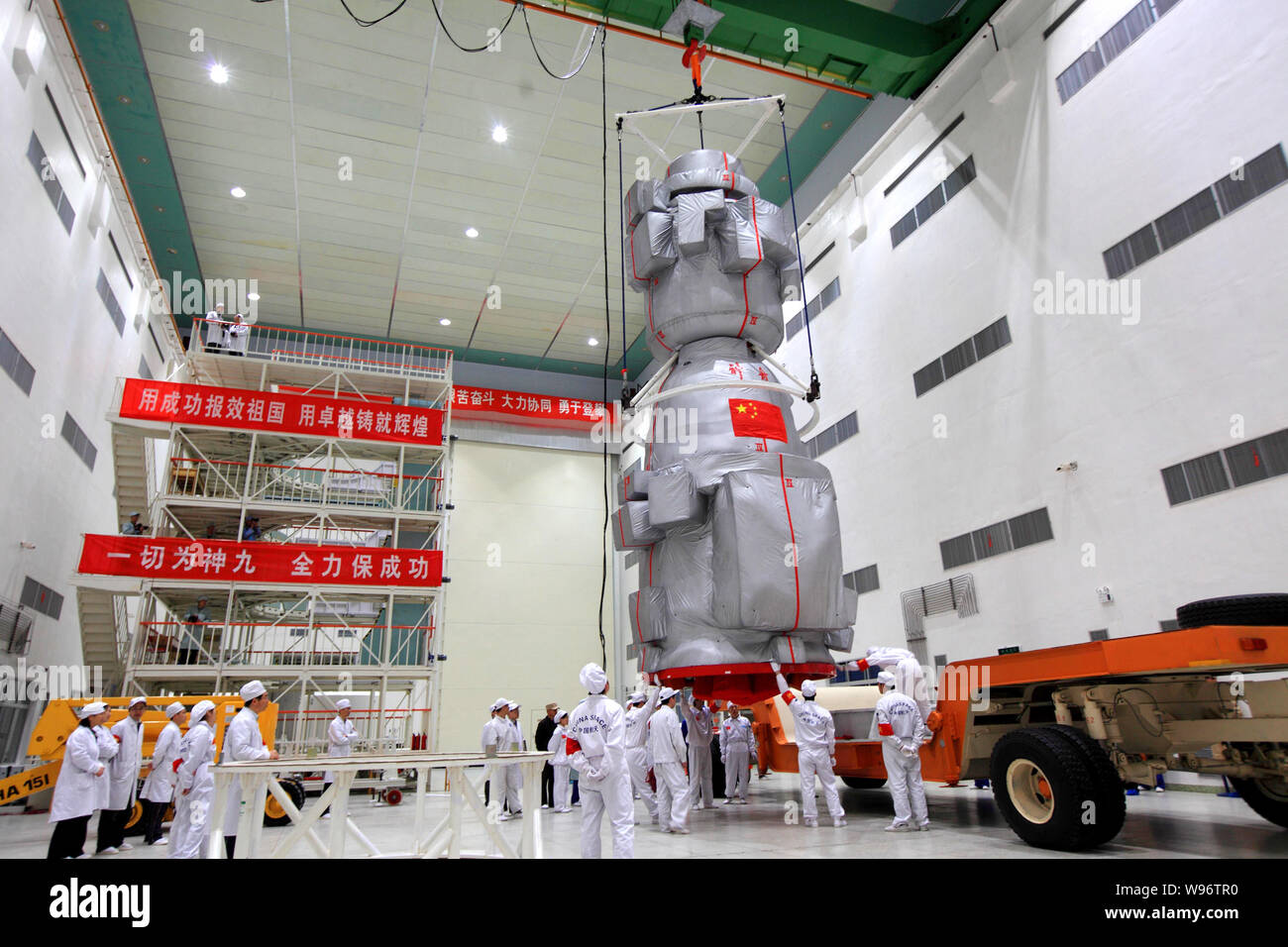 The Shenzhou-9 (Shenzhou IX) spacecraft is being lifted and put on a ...