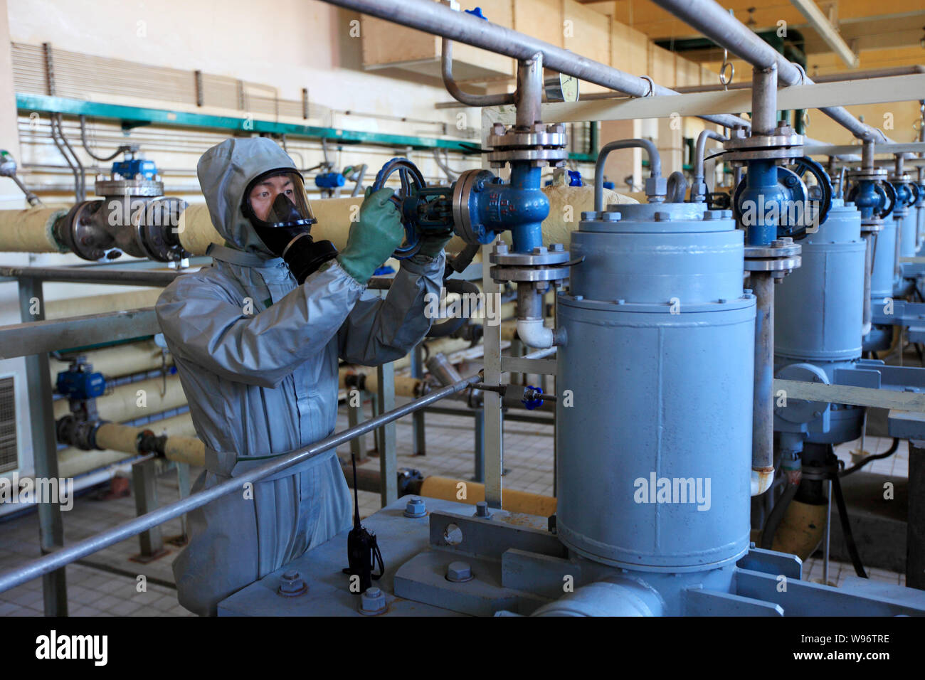 A Chinese technician wearing a protective suit checks the equipment ...