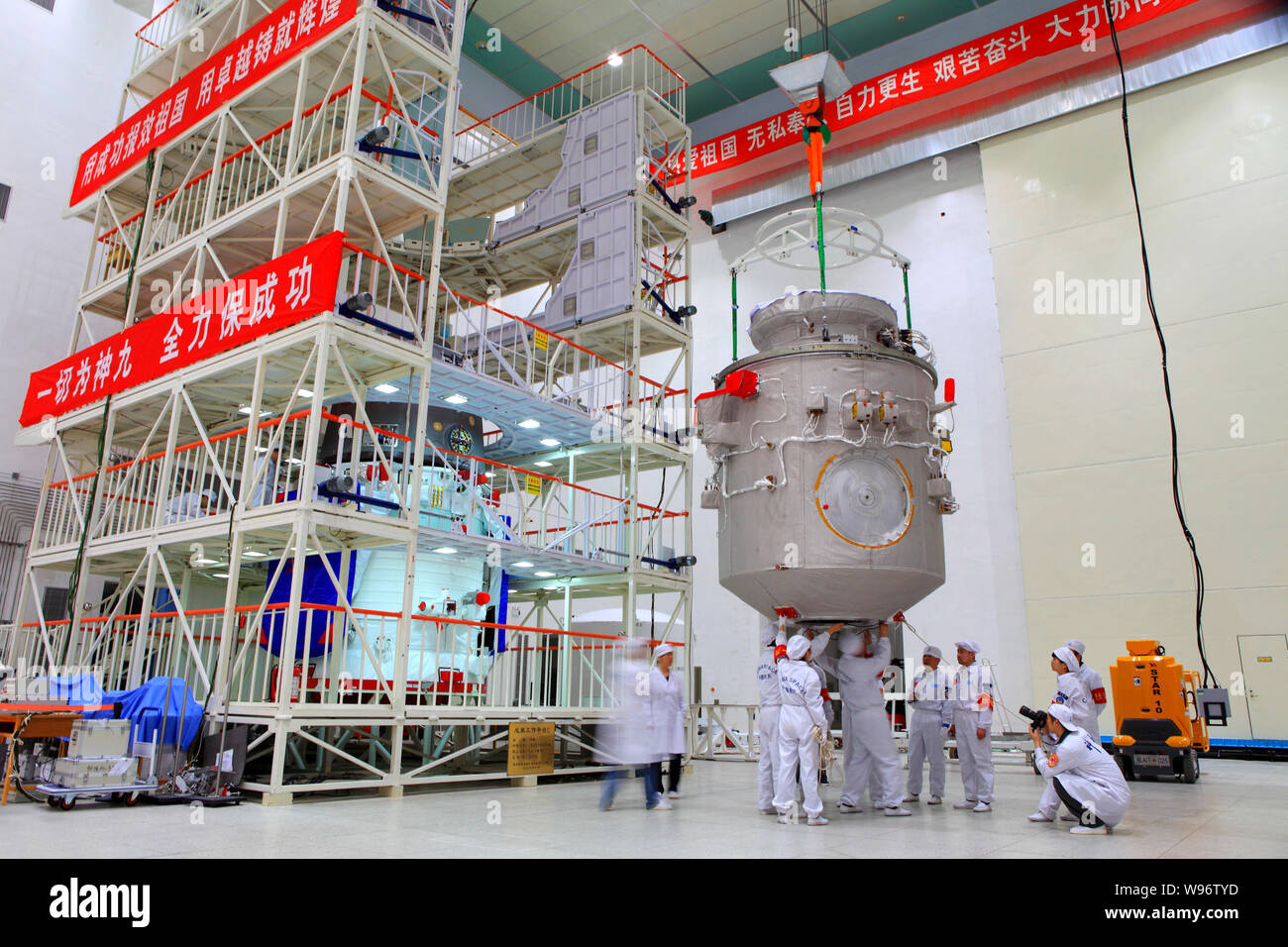 Chinese aerospace engineers check the orbital module of the Shenzhou-9 ...