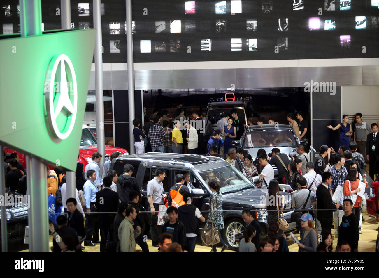 Visitors crowd around Land Rover and Range Rover SUVs during the 12th ...