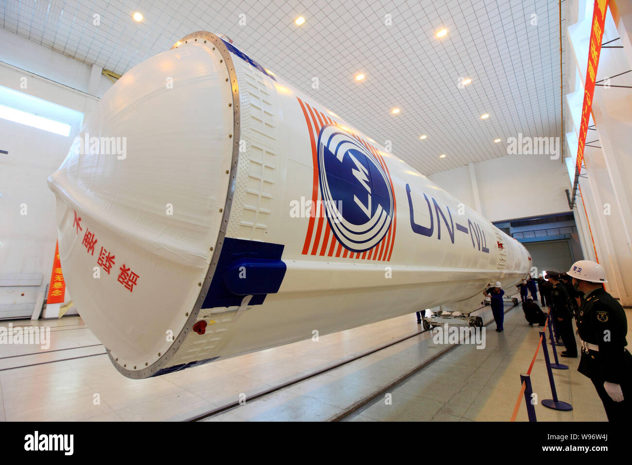 Chinese staff members tow the first stage of a Long March 2F (CZ-2F ...