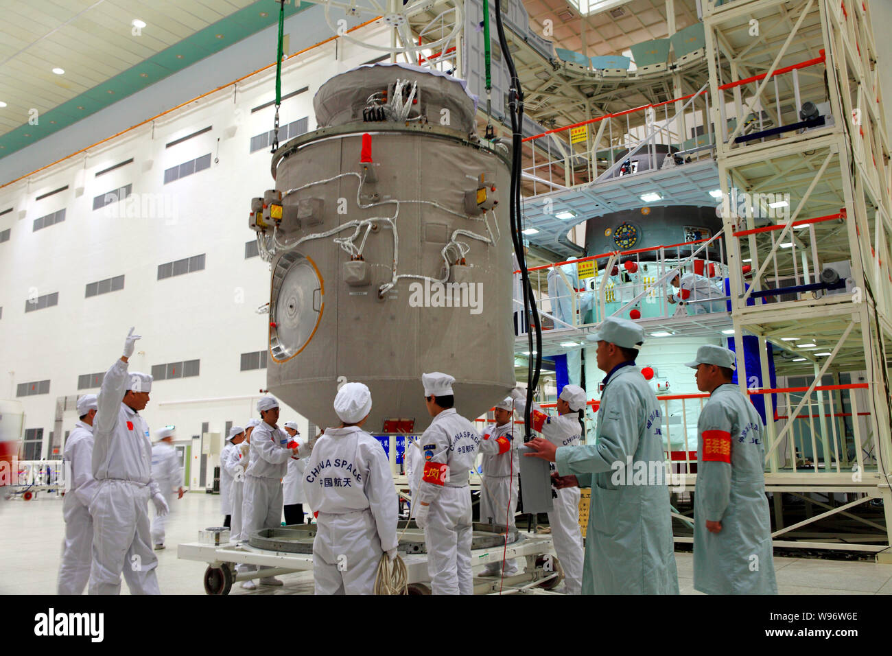 Chinese aerospace engineers check the orbital module of the Shenzhou-9 ...