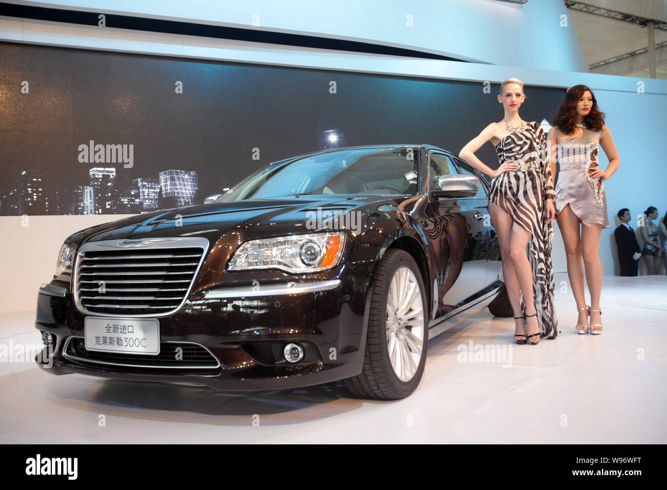 Models pose with a new Chrysler 300C in the preparation for the 12th ...
