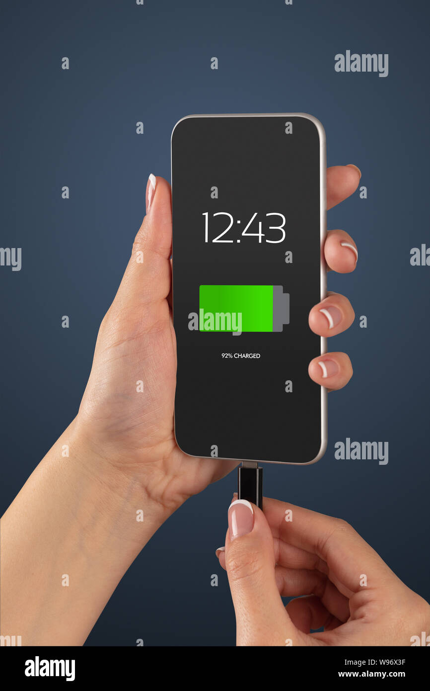Elegant hand charging smartphone with low battery Stock Photo - Alamy
