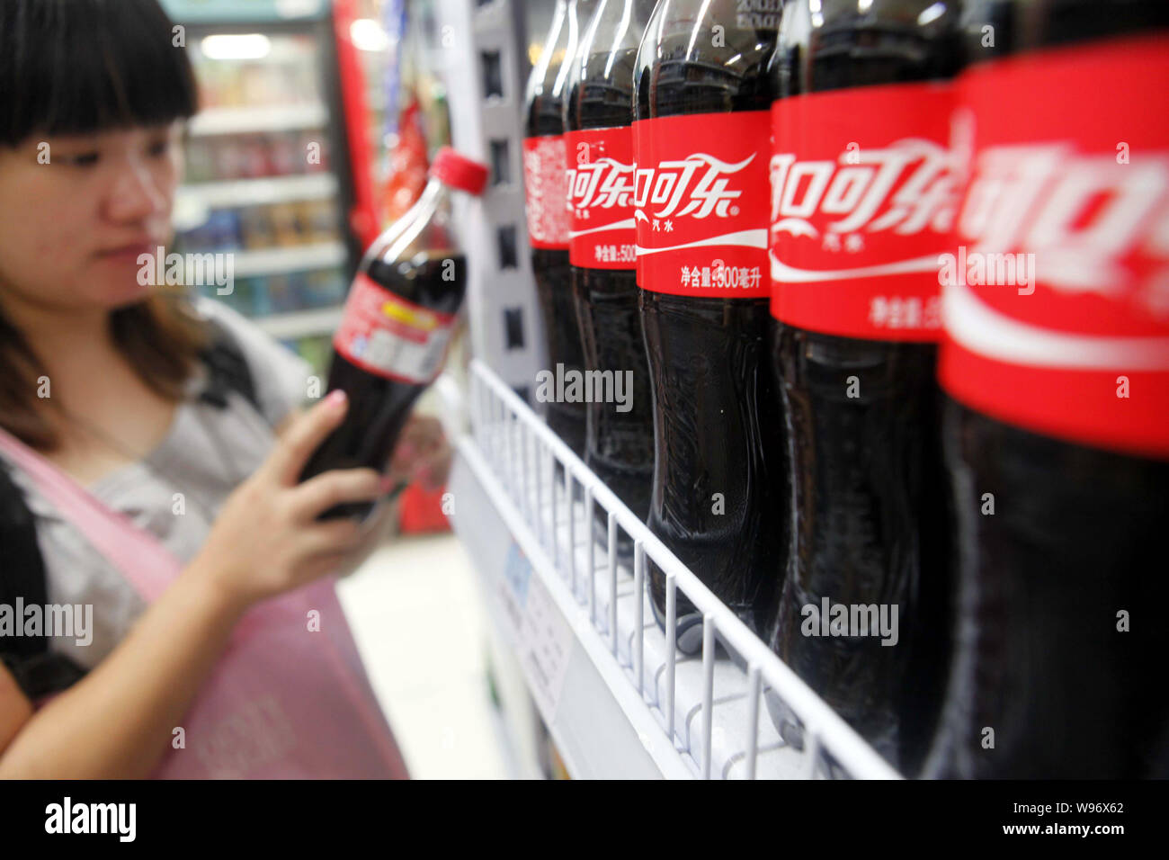 --FILE--A Chinese customer shops for bottled Coca-Cola drink at a ...
