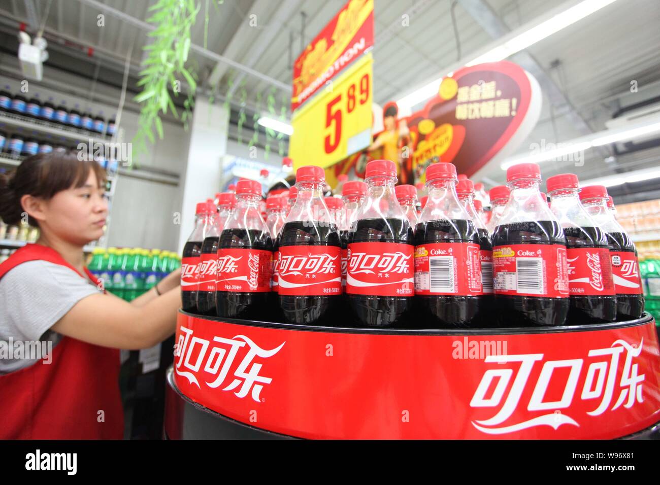 --File--A Chinese staff puts bottles of Coke on the shelf at a ...
