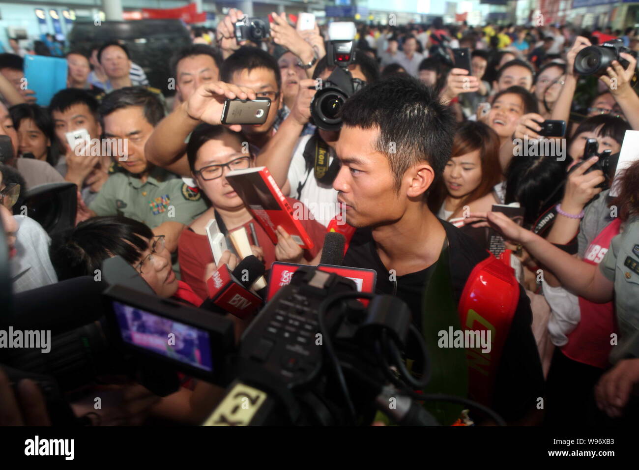 Chinese Olympic badminton champion Lin Dan (black) is interviewed at ...