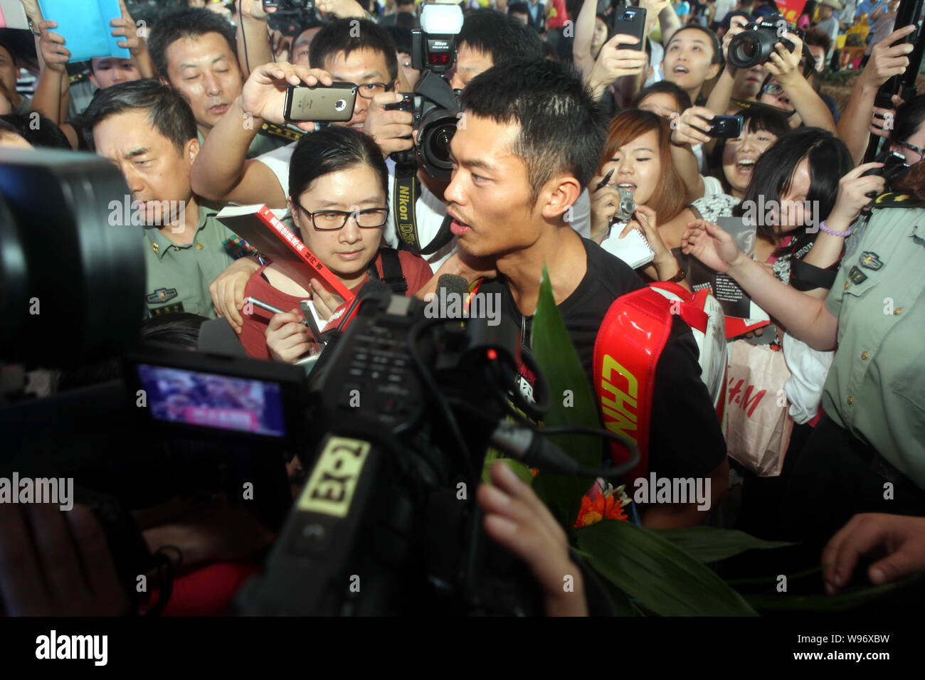 Chinese Olympic badminton champion Lin Dan (black) is interviewed at ...