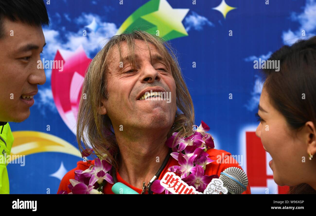 French Spiderman Alain Robert, center, is interviewed after finishing ...
