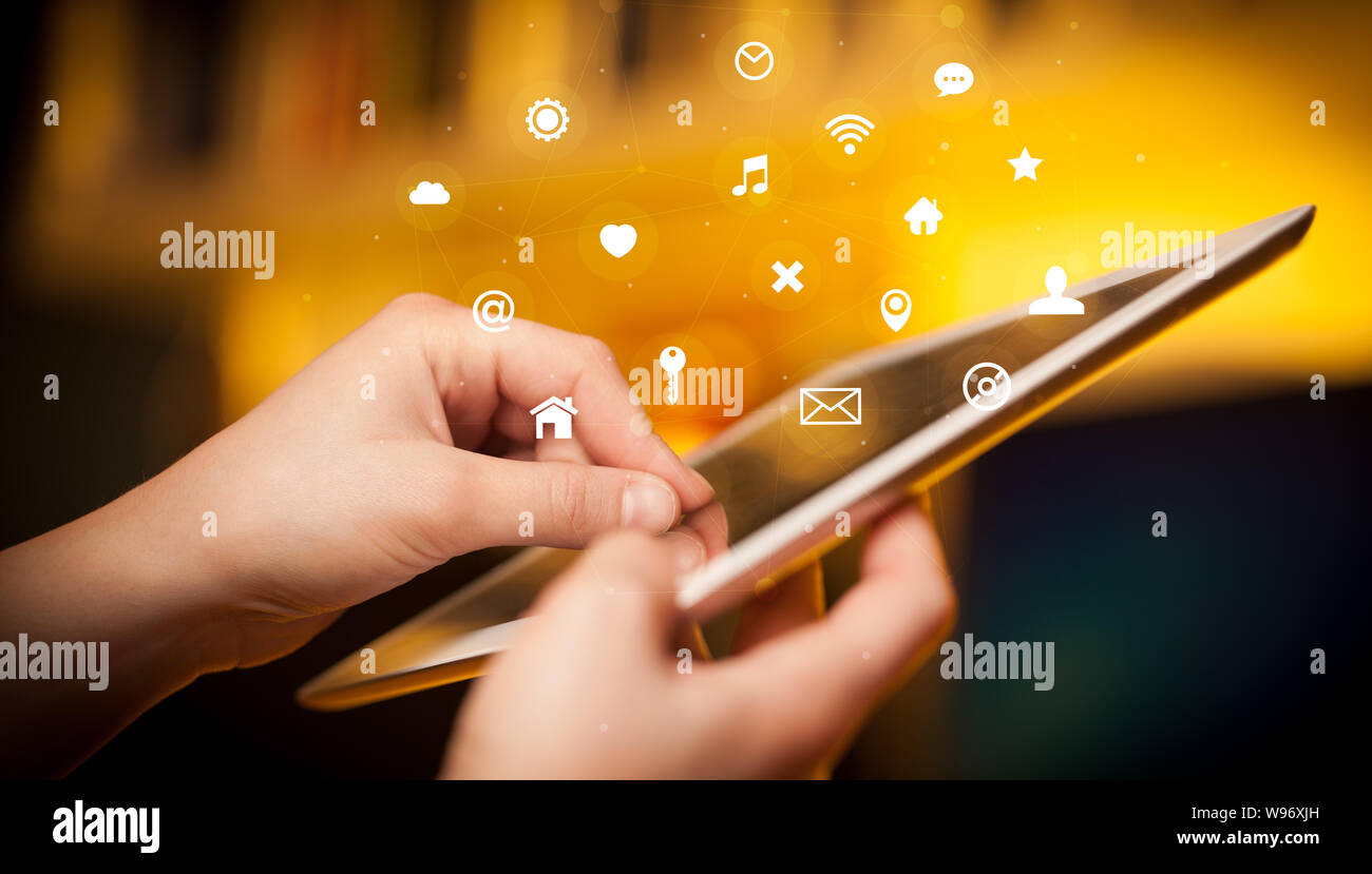 Hand holding tablet with multimedia and application symbols concept ...