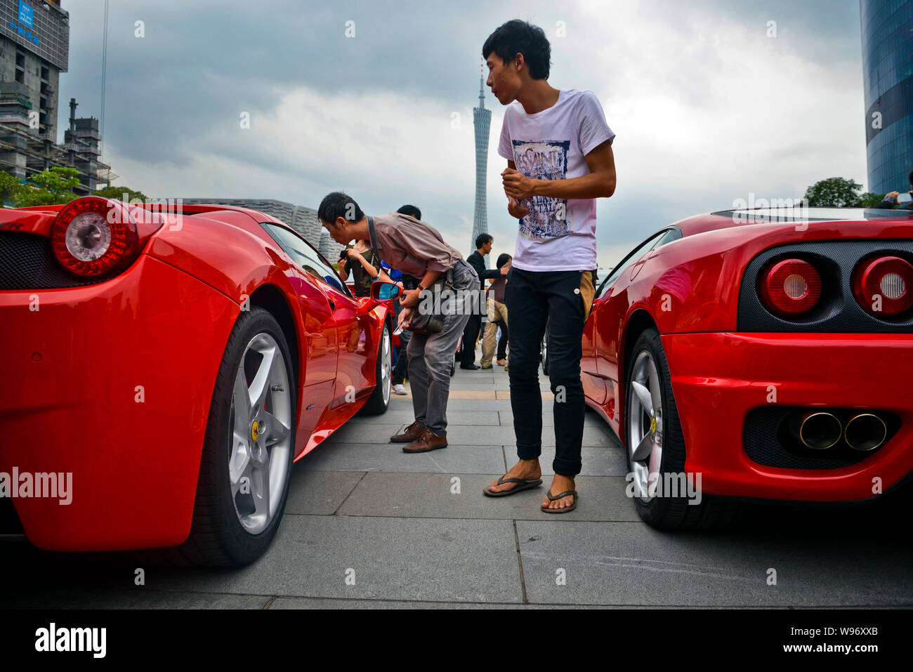 People look at Ferrari sports cars lined up during a parade to ...