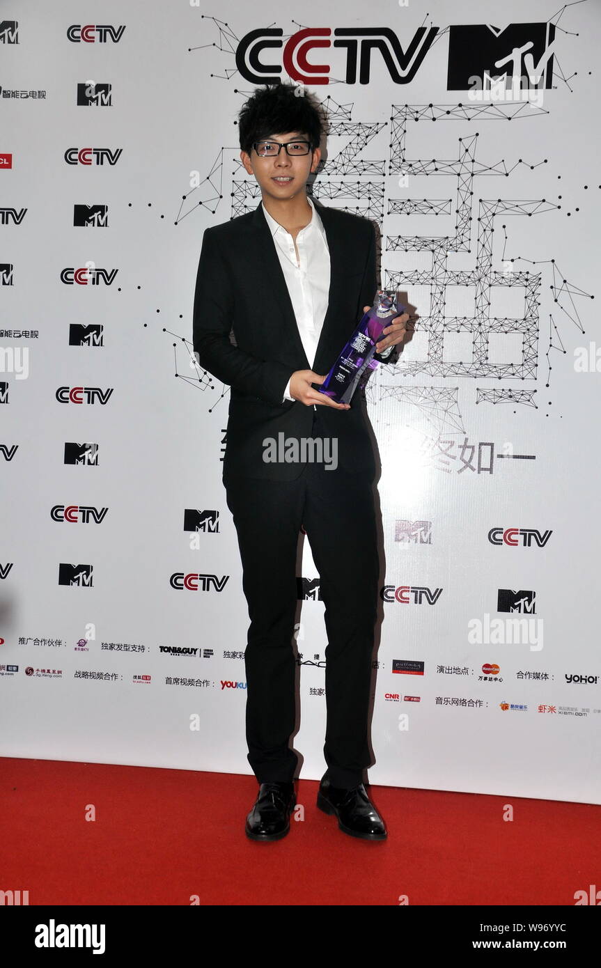 Chinese singer Hu Xia holds his trophy for the best new talent in the ...