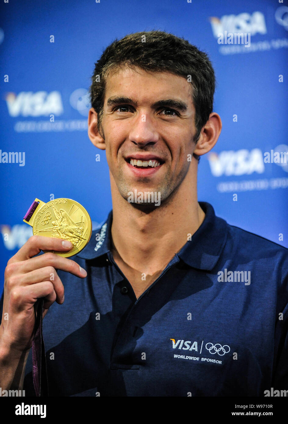 US swimmer Michael Phelps shows one of his gold medals at a press ...
