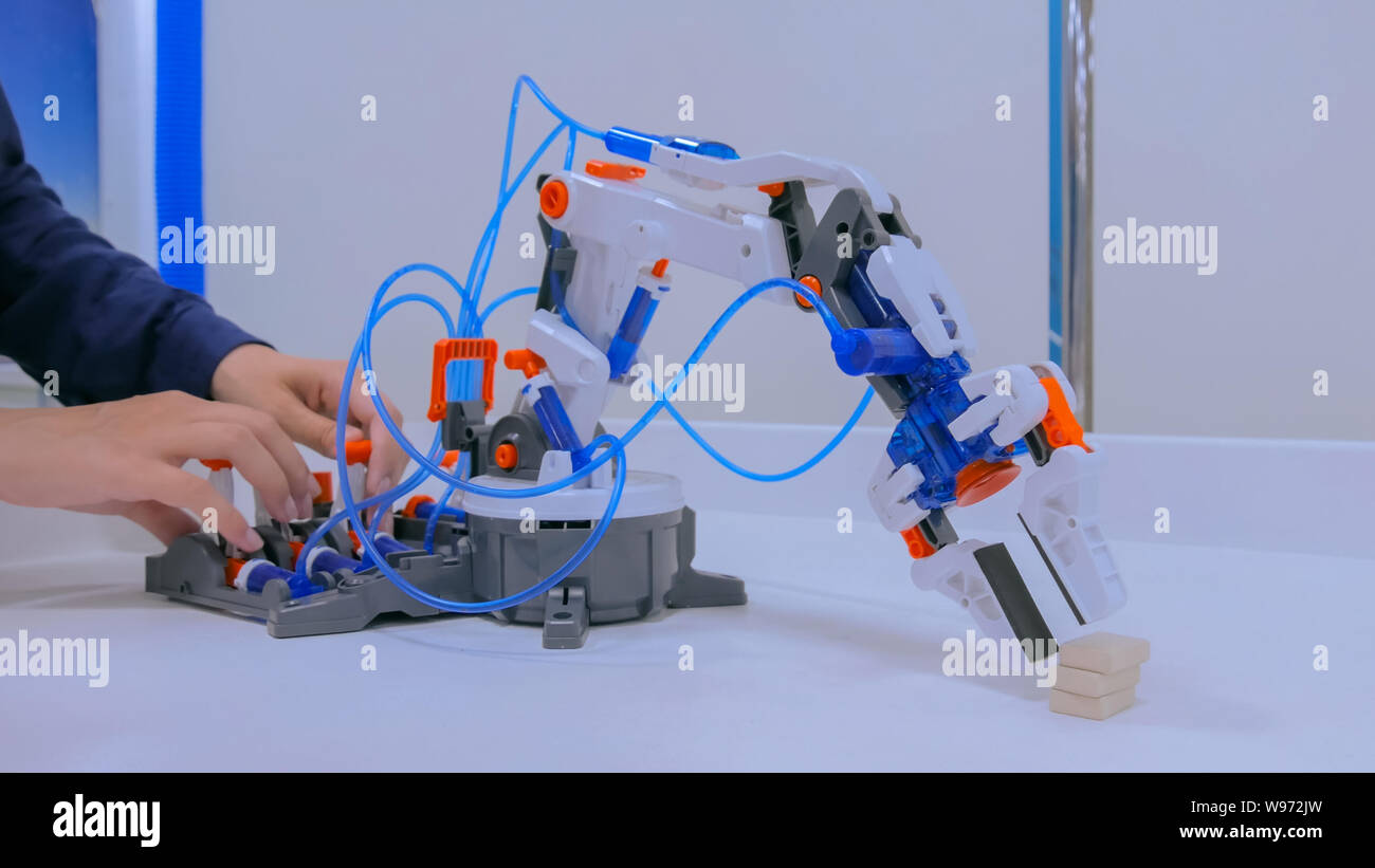 Woman controls robot hand manipulator at technology exhibition Stock ...