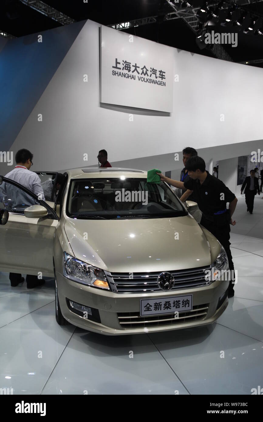 Visitors look at a New Santana of Shanghai Volkswagen, a joint venture ...